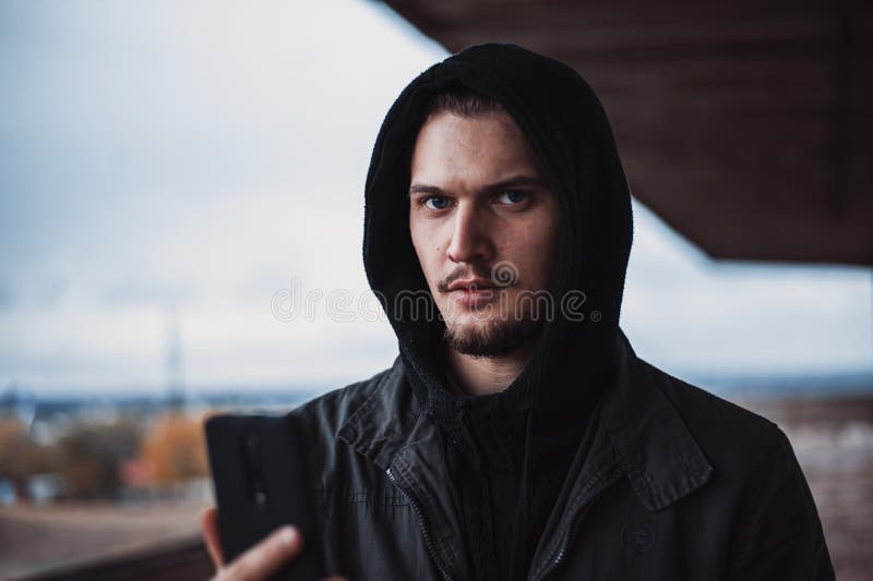 Deep Sight of Young Man Looking in Camera with Smartphone in His Hand ...