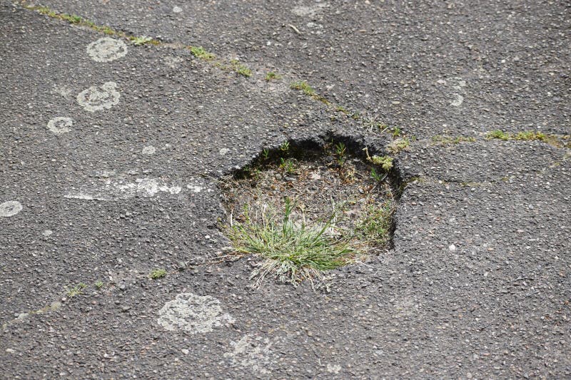 A Deep Single Pothole with Some Grass Growing in it Stock Image - Image ...