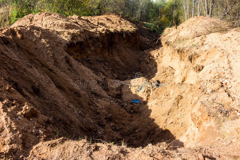 A Deep Trench Dug in Sandy Soil in a Forest Area for Laying Engineering ...