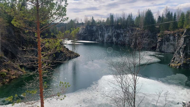 A Deep, Water-filled Marble Quarry is Visible, with Large Cliffs and ...