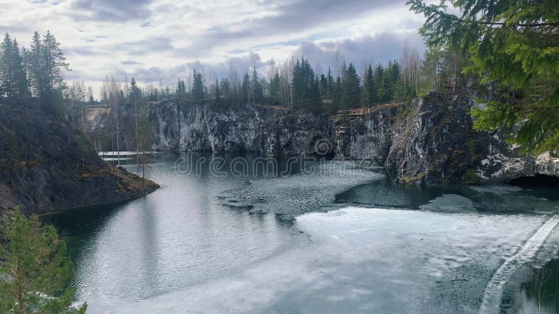A Deep, Water-filled Marble Quarry is Visible, with Large Cliffs and ...