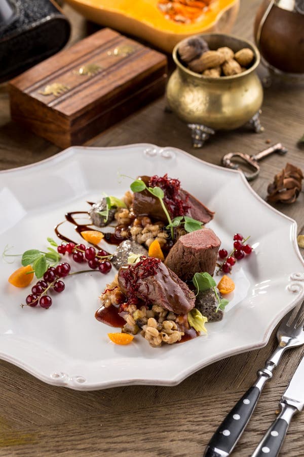 Deer Chops with Pearl Barley and Cranberry Sauce on Wooden Table Stock ...