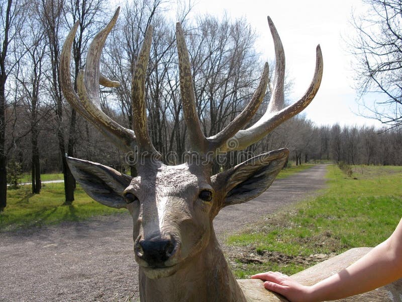 Deer Statue with Large Antlers in a Park with Bare Trees and a Gravel ...