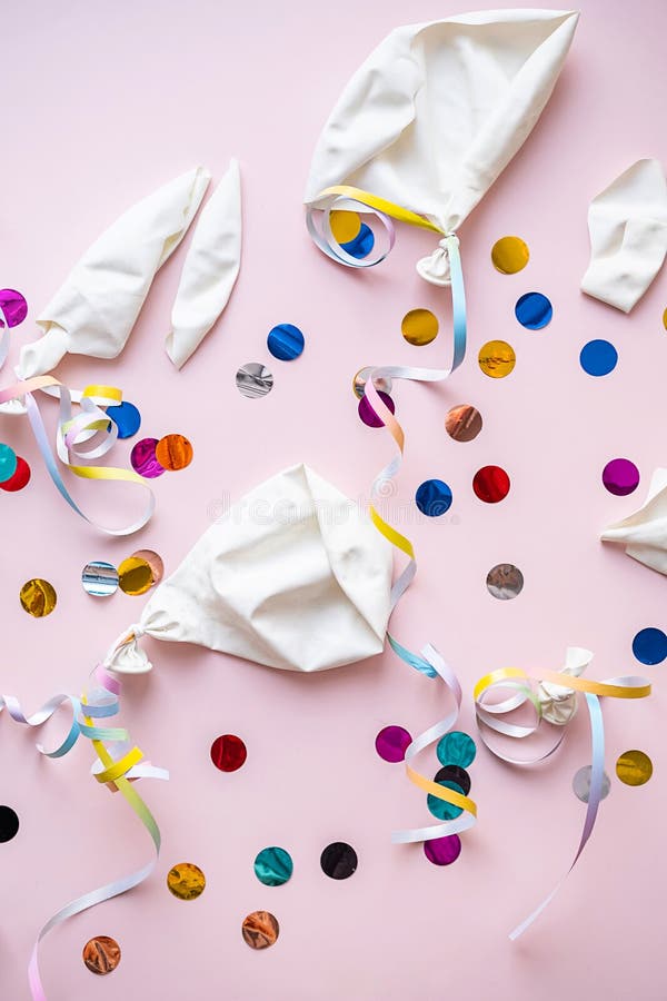 Deflated Balloons and Colourful Confetti Scattered on Pink Stock Photo ...