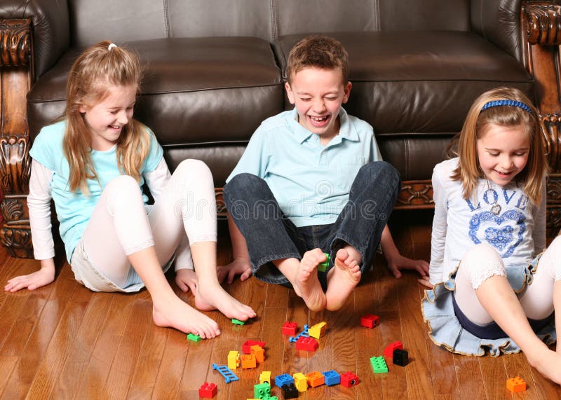 Bambini Che Solleticano I Piedi Con La Piuma Immagine Stock - Immagine ...