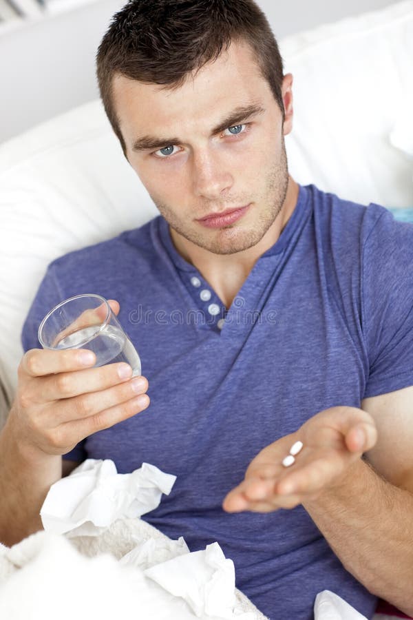 Dejected Man Holding Pills and Water on the Sofa Stock Photo - Image of ...
