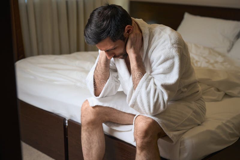 Dejected Man is Sitting on Large Bed in Hotel Room Stock Image - Image ...