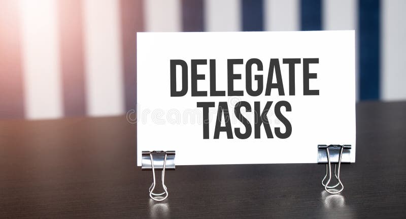 Delegate Tasks Sign on Paper on Dark Desk in Sunlight. Blue and White ...