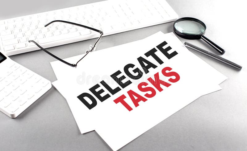 DELEGATE TASKS Text on a Paper on a Gray Background Near a Calculator ...