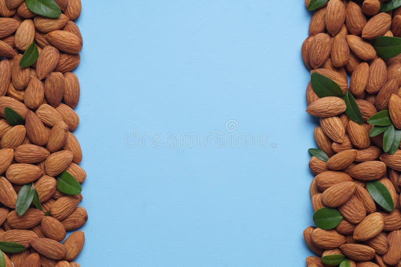 Delicious Almonds and Fresh Leaves on Light Blue Background, Flat Lay ...