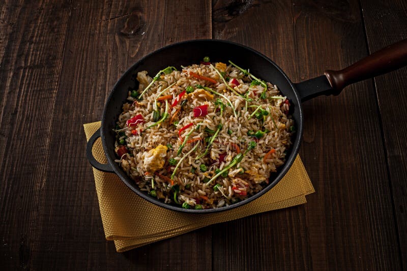 Delicious Asian Rice on a Black Cast Iron with Wood Stock Photo - Image ...