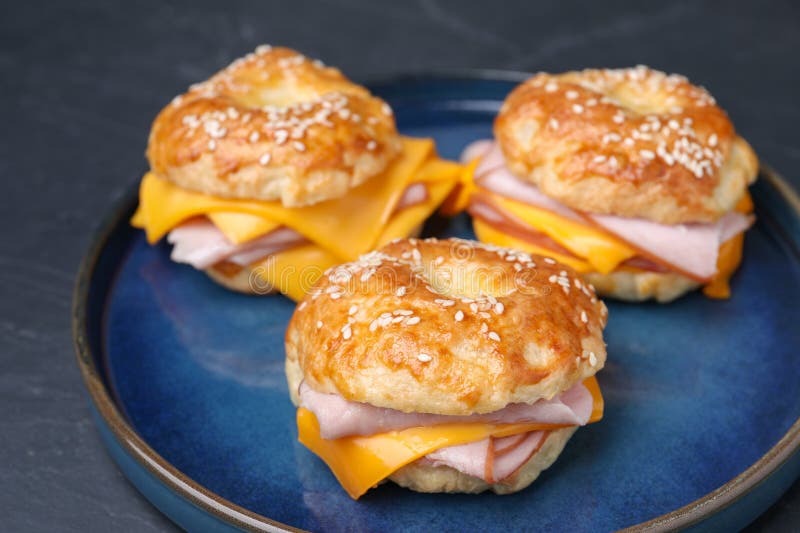 Delicious Bagels with Ham and Cheese on Black Table, Closeup Stock ...