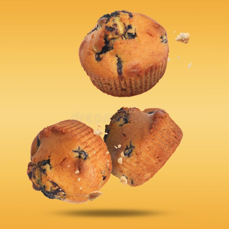 Delicious Blueberry Muffins Falling on Golden Background Stock Photo ...