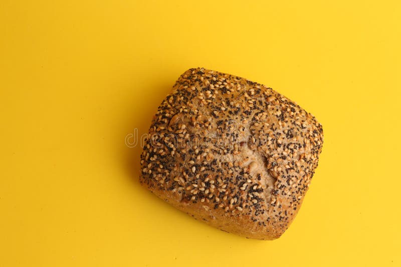 Delicious Brown Bread Covered in Sesame Seeds on the Yellow Surface ...