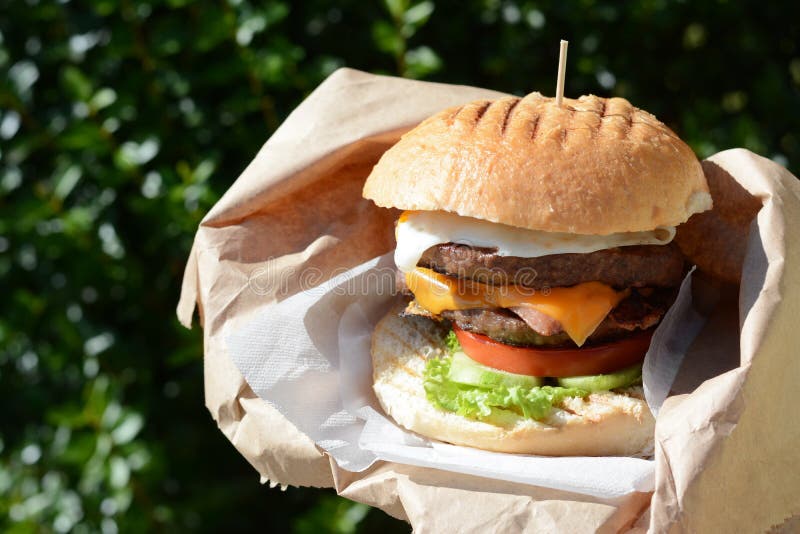 Delicious Burger in Paper Wrap Outdoors, Closeup Stock Image - Image of ...