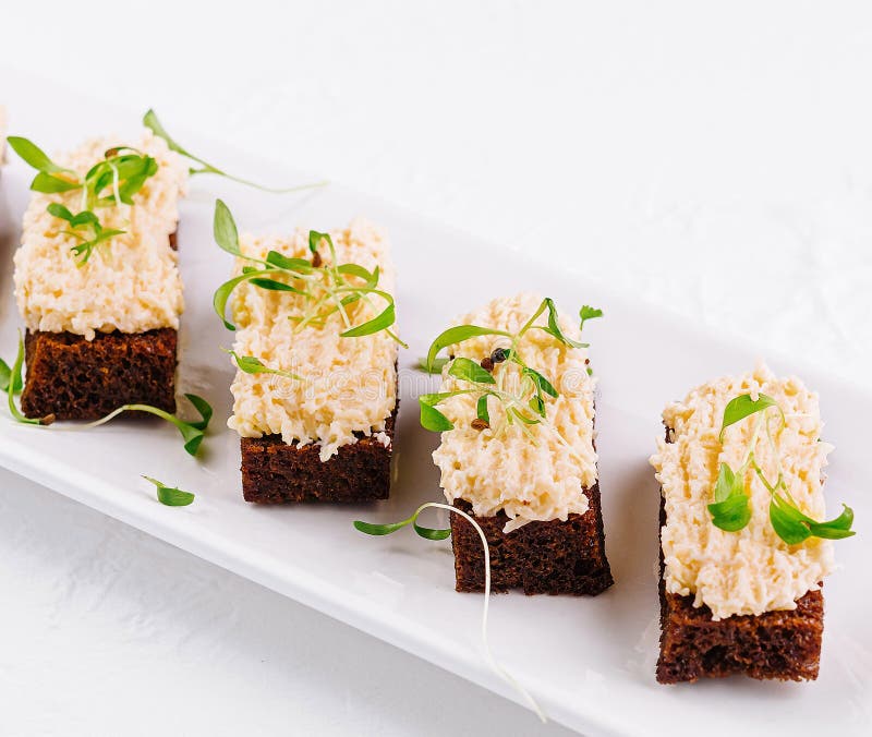 Delicious Canapes with Cream Cheese and Greens Lying on White Plate ...