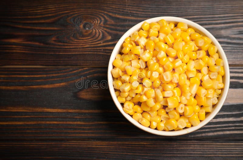 Delicious Canned Corn in Bowl on Wooden Table, Top View. Space for Text ...