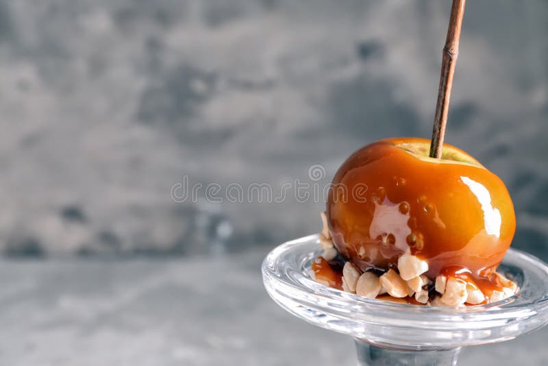 Delicious Caramel Apple with Tree Branch on Glass Stand Stock Image ...