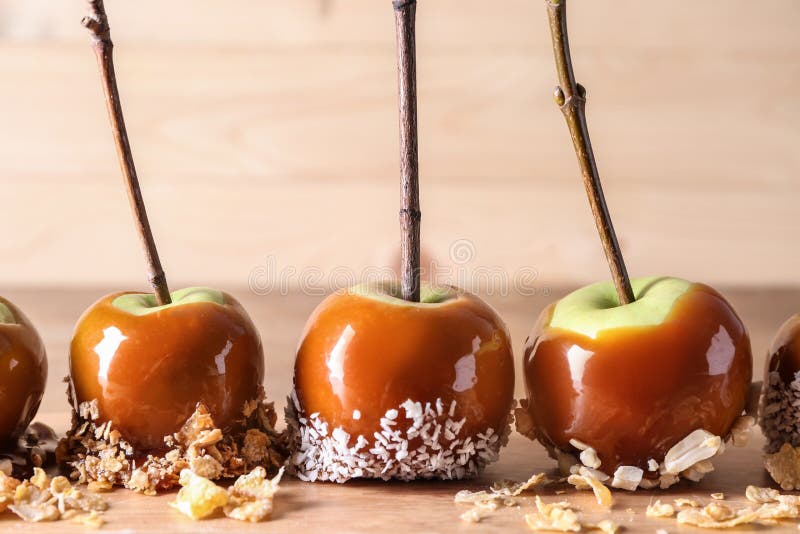 Delicious Caramel Apples with Tree Branches on Wooden Board Stock Photo ...