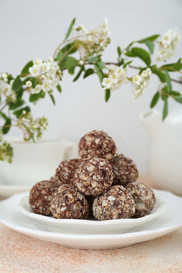 Delicious Chocolate Candies Under Blooming Branch on Beige Table Stock ...