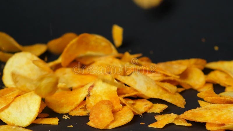 Delicious Crispy Thin Potato Chips Fall from Top To Bottom on a Black ...