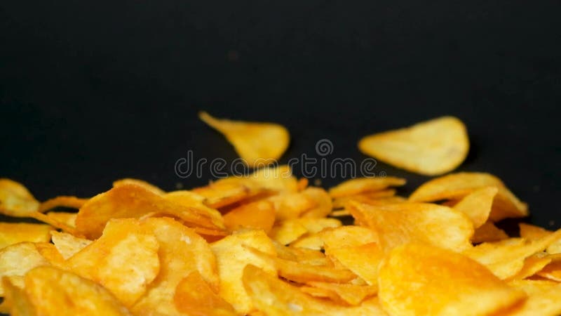 Delicious Crispy Thin Potato Chips Fall from Top To Bottom on a Black ...