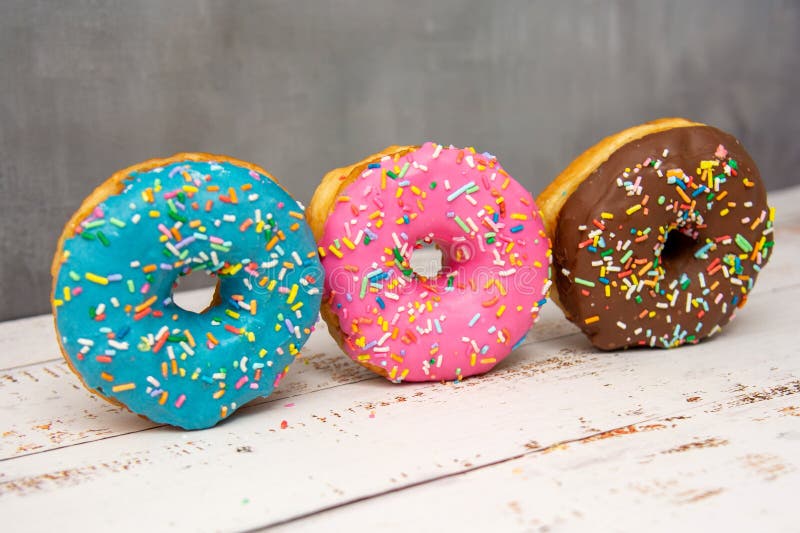 Delicious Dessert. Pink, Blue and Chocolate Donuts with Multicolored ...