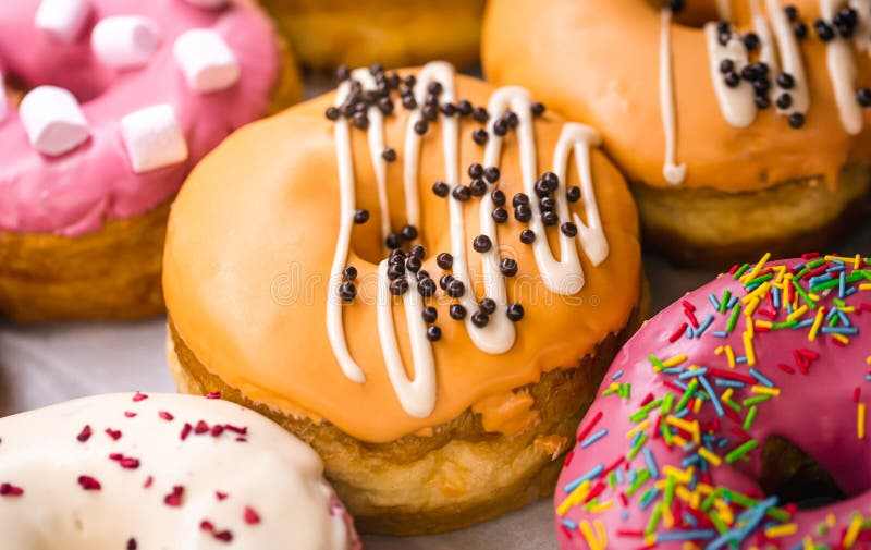 Delicious Donuts of Different Flavors on Paper Close Up. Stock Image ...