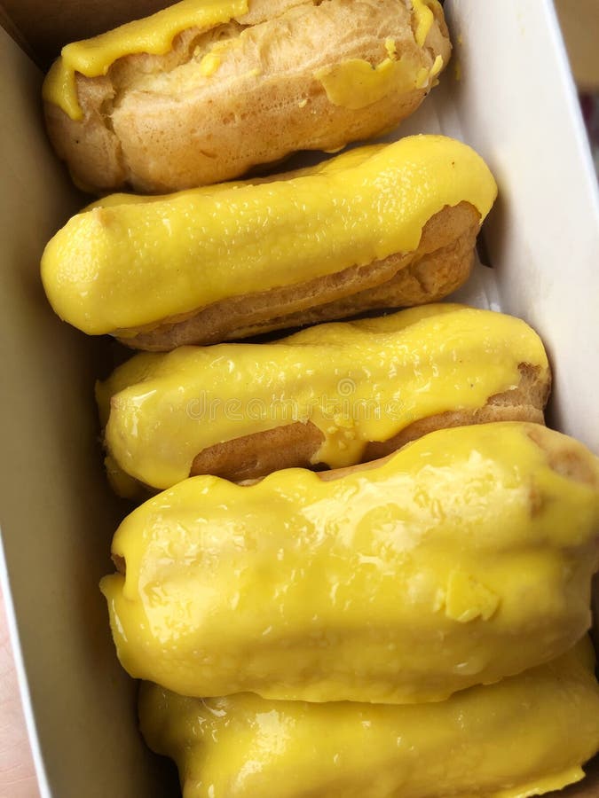 Delicious Eclairs with Yellow Glaze in a Box Stock Image - Image of ...