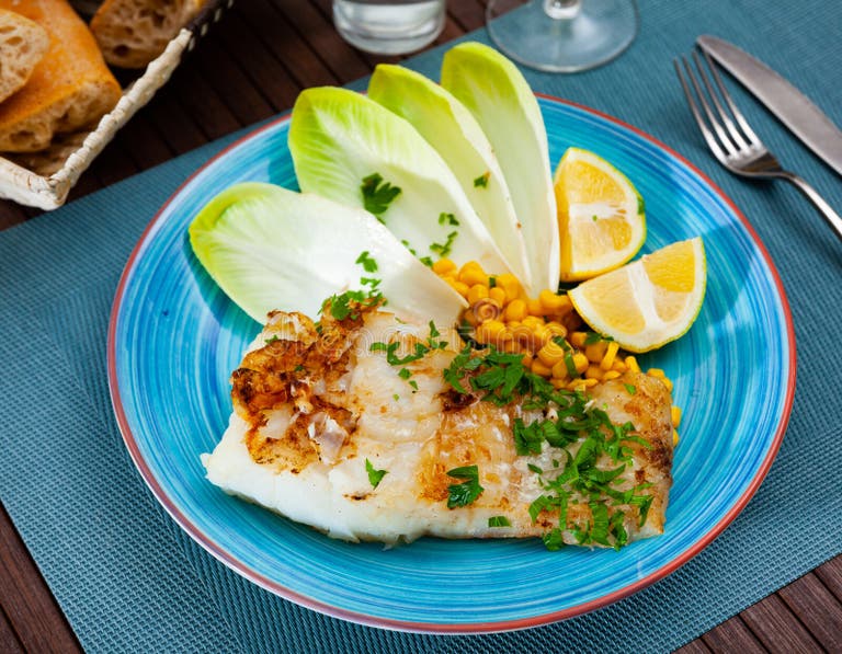 Delicious Fried Cod Fillet with Endive, Corn, and Greens Stock Photo ...