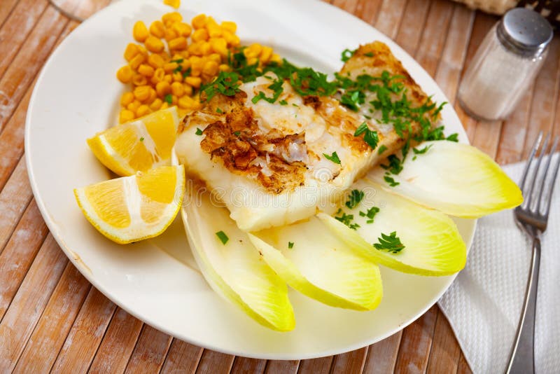 Delicious Fried Cod Fillet with Endive, Corn, and Greens Stock Photo ...