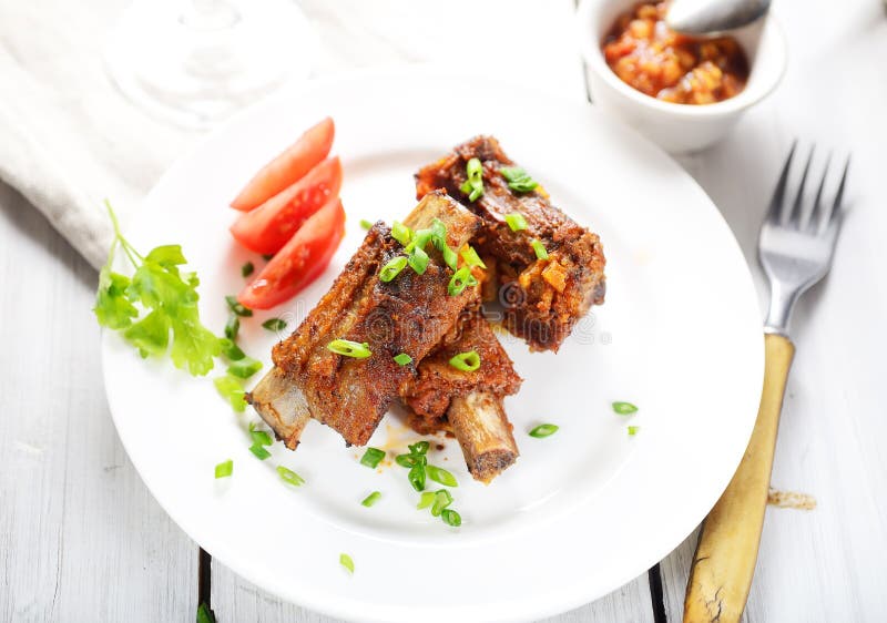 Delicious Fried Pork Ribs on a Plate, Sauce, Fork, Greens Stock Photo ...