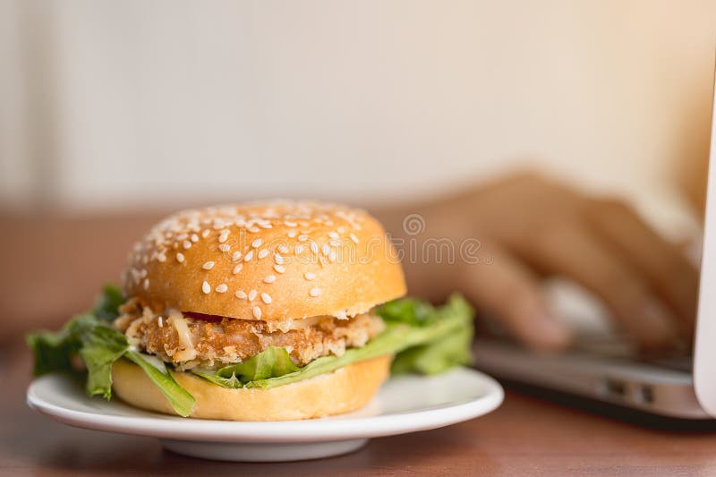 A Delicious Hamburger on the Table while Working on Laptop Computer ...