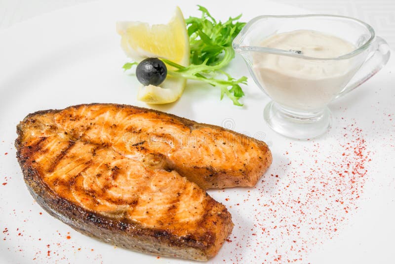 A Delicious Large Piece of Fried Fish with Sauce, Lemon and Herbs ...