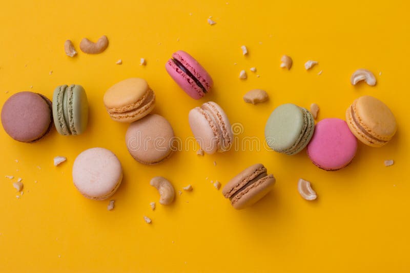 Delicious Macarons with Pieces of Nuts on Yellow Background. Stock ...