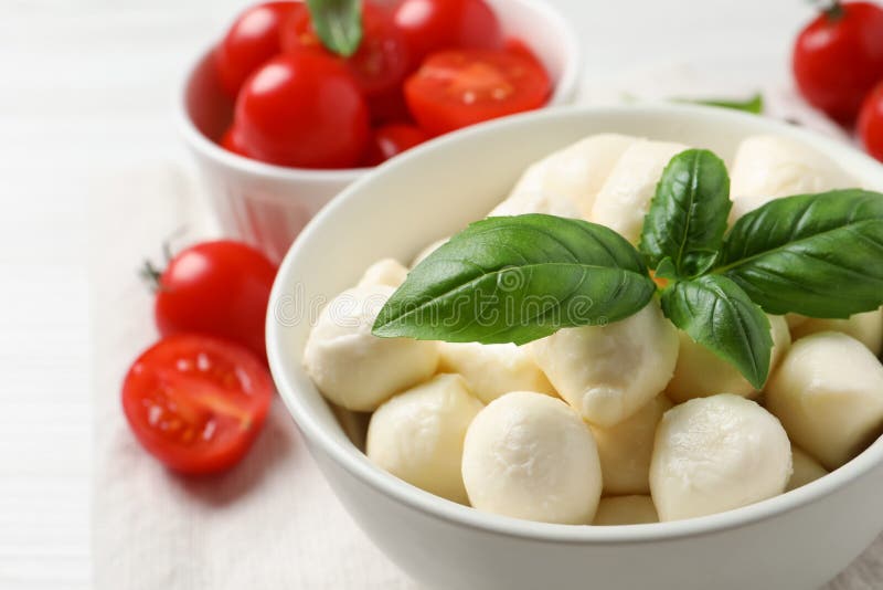 Delicious Mozzarella Balls and Basil Leaves in Bowl on Table, Closeup ...