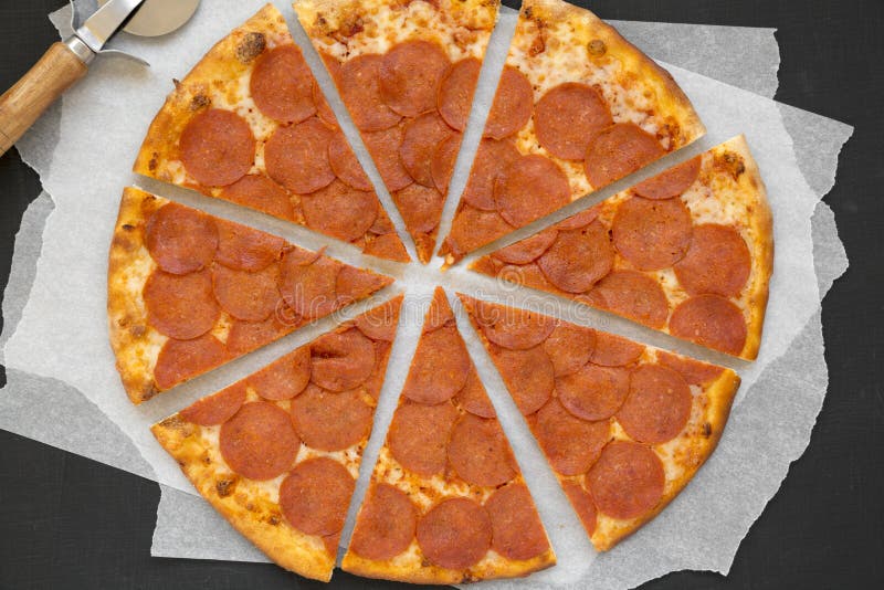 Delicious Pepperoni Pizza on Parchment Over Black Surface, Top View ...