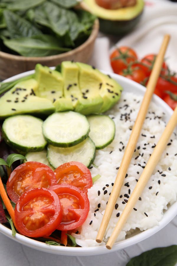 Delicious Poke Bowl with Vegetables, Avocado and Mesclun on White Table ...