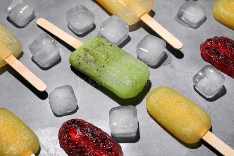 Delicious Pops and Ice Cubes on Grey Table. Fruit Popsicle Stock Image ...