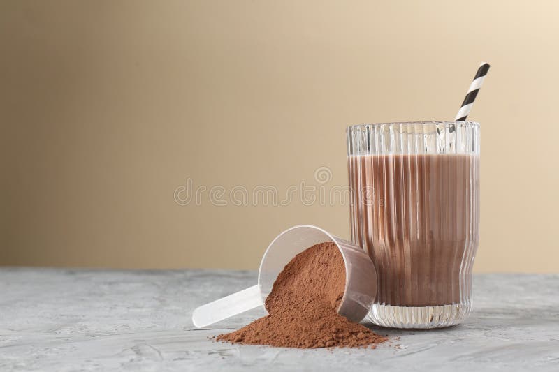 Delicious Protein Shake in Glass and Scoop with Powder on Grey Table ...