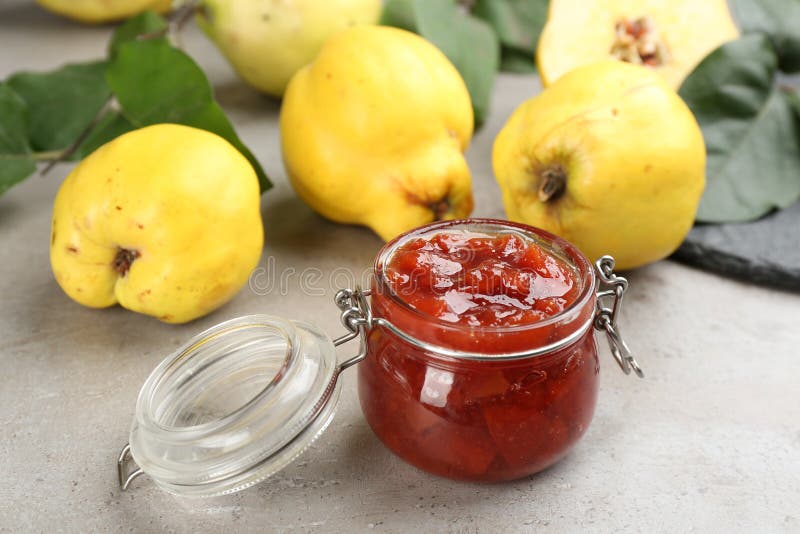 Delicious Quince Jam and Fruits on Light Grey Table, Closeup Stock ...
