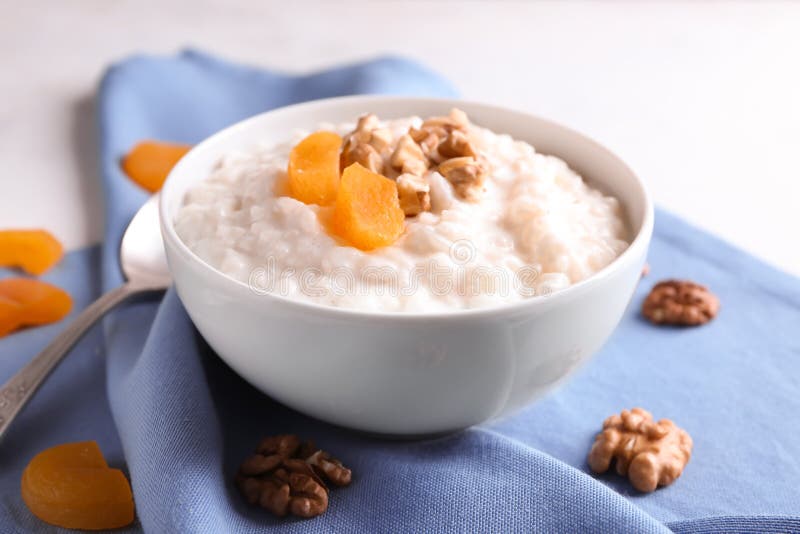 Delicious Rice Pudding with Dried Apricots and Walnut in Bowl on Table ...