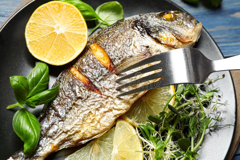 Delicious Roasted Fish with Lemon and Greens on Plate Stock Image ...