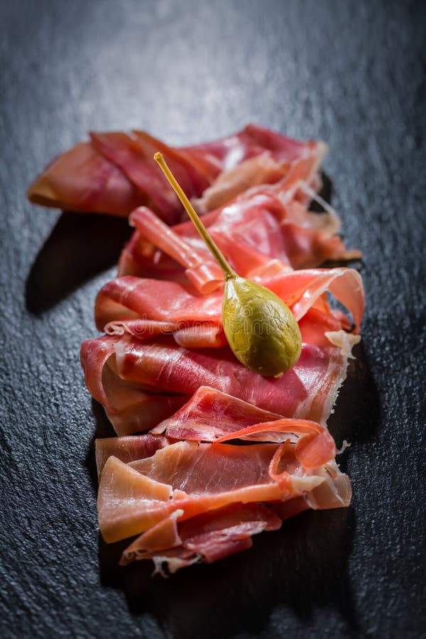Delicious Serrano Ham Hanging from a Rope. Isolated on Black ...