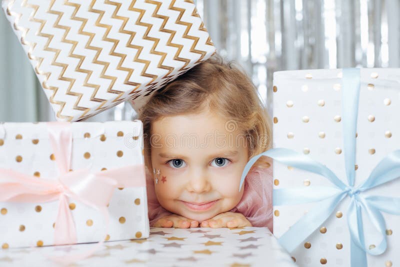Delighted Little Girl is Sitting among Lot of Gift Boxes, Resting Her ...