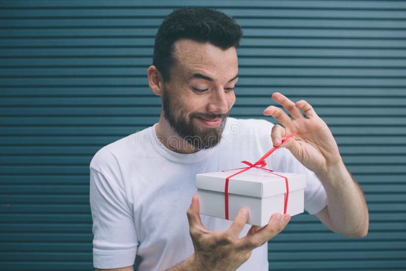 Man Opening a Gift Box while Her Girlfriend Sitting Close To Her on ...