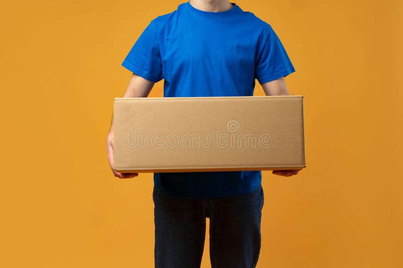 Delivery Courier Holds Large Parcel on Blue Background Stock Photo ...