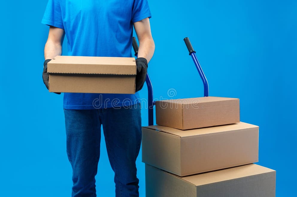 Delivery Courier Holds Large Parcel on Blue Background Stock Photo ...