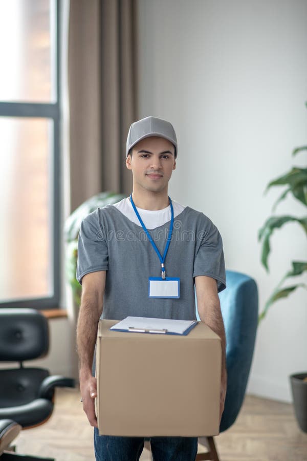 Delivery Courrier in a Cap Standing with a Big Box in His Hands Stock ...