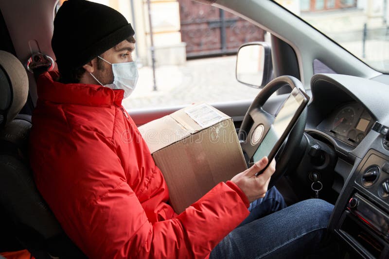 Delivery Driver Checking Something at the Tablet while Sitting at the ...